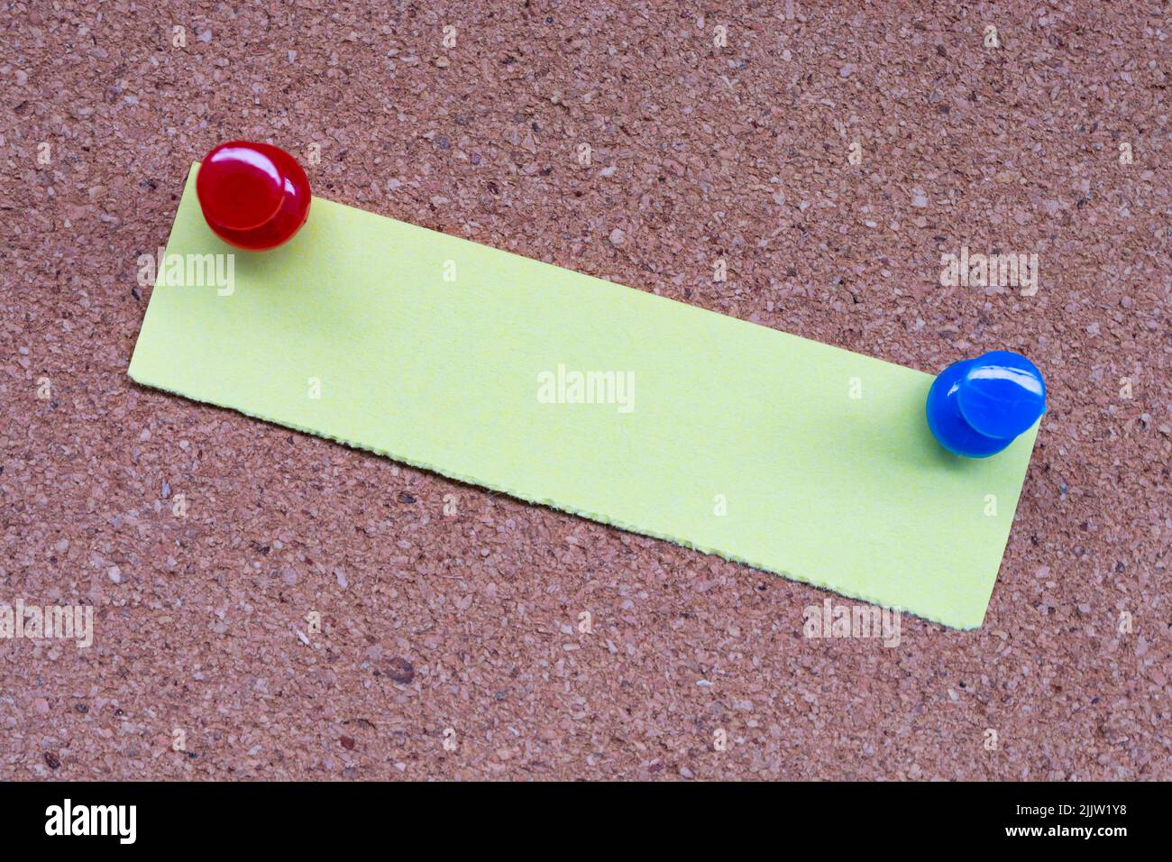Yellow stick note and pinned to a cork notice board. Copy space ...