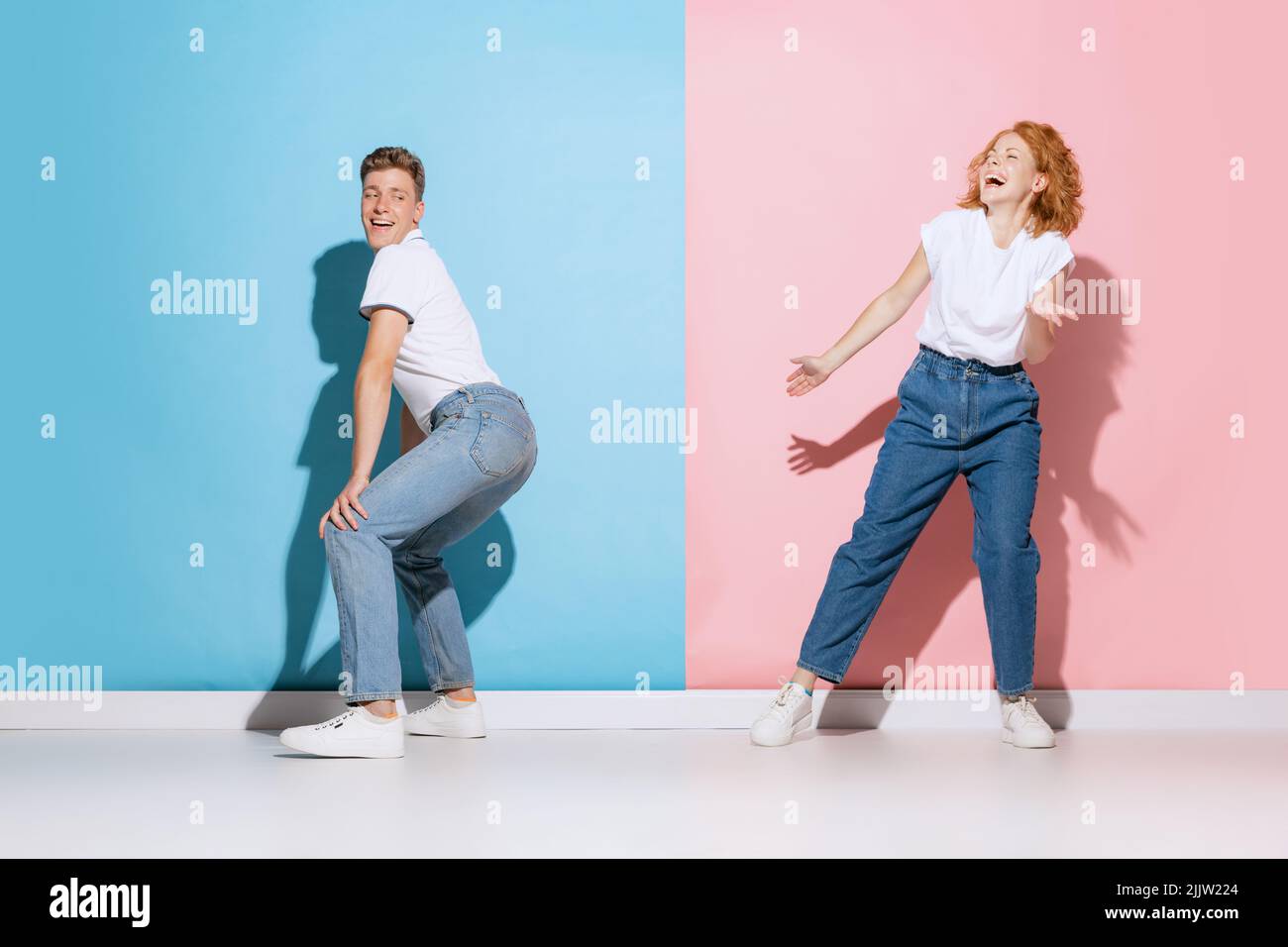 Portrait of young emotive couple, cheerfully dancing, posing isolated ...