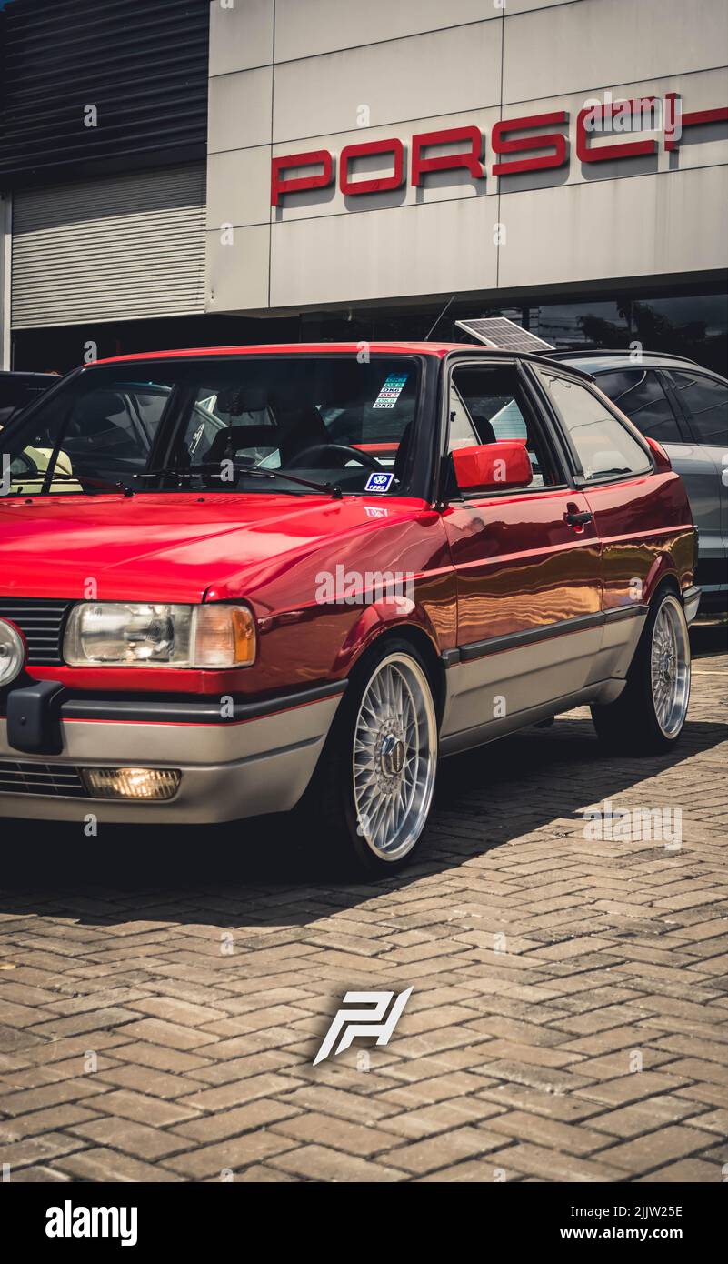 A Volkswagen 1993 Red Gol GTI in front of a Porsche building Stock ...