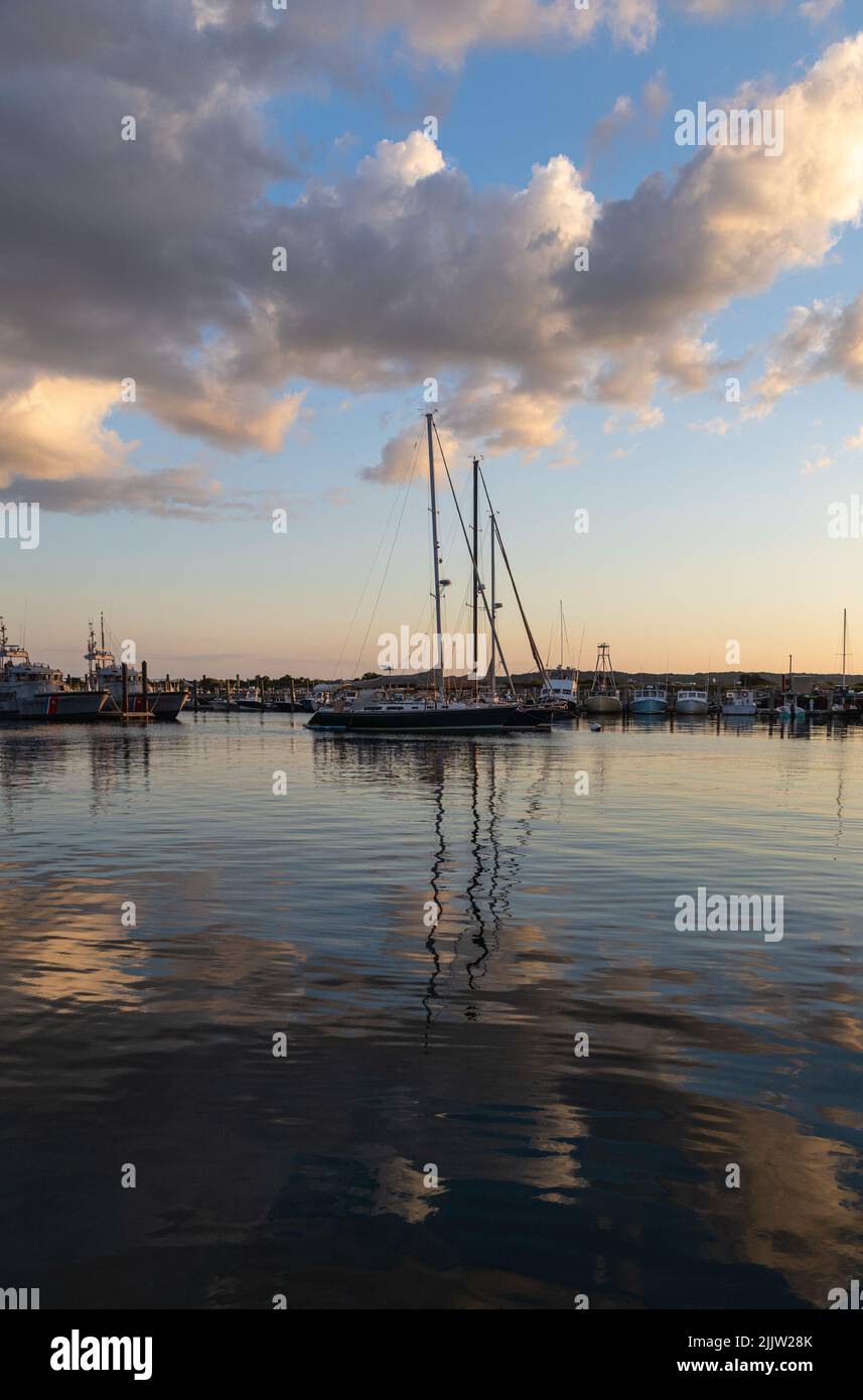 A vertical shot of sailboats in harbor at scenic sunset in Martha's ...