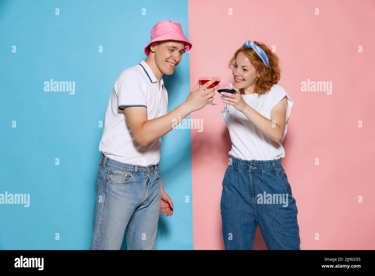 Portrait of young couple celebrating event, clinking cocktail glasses ...