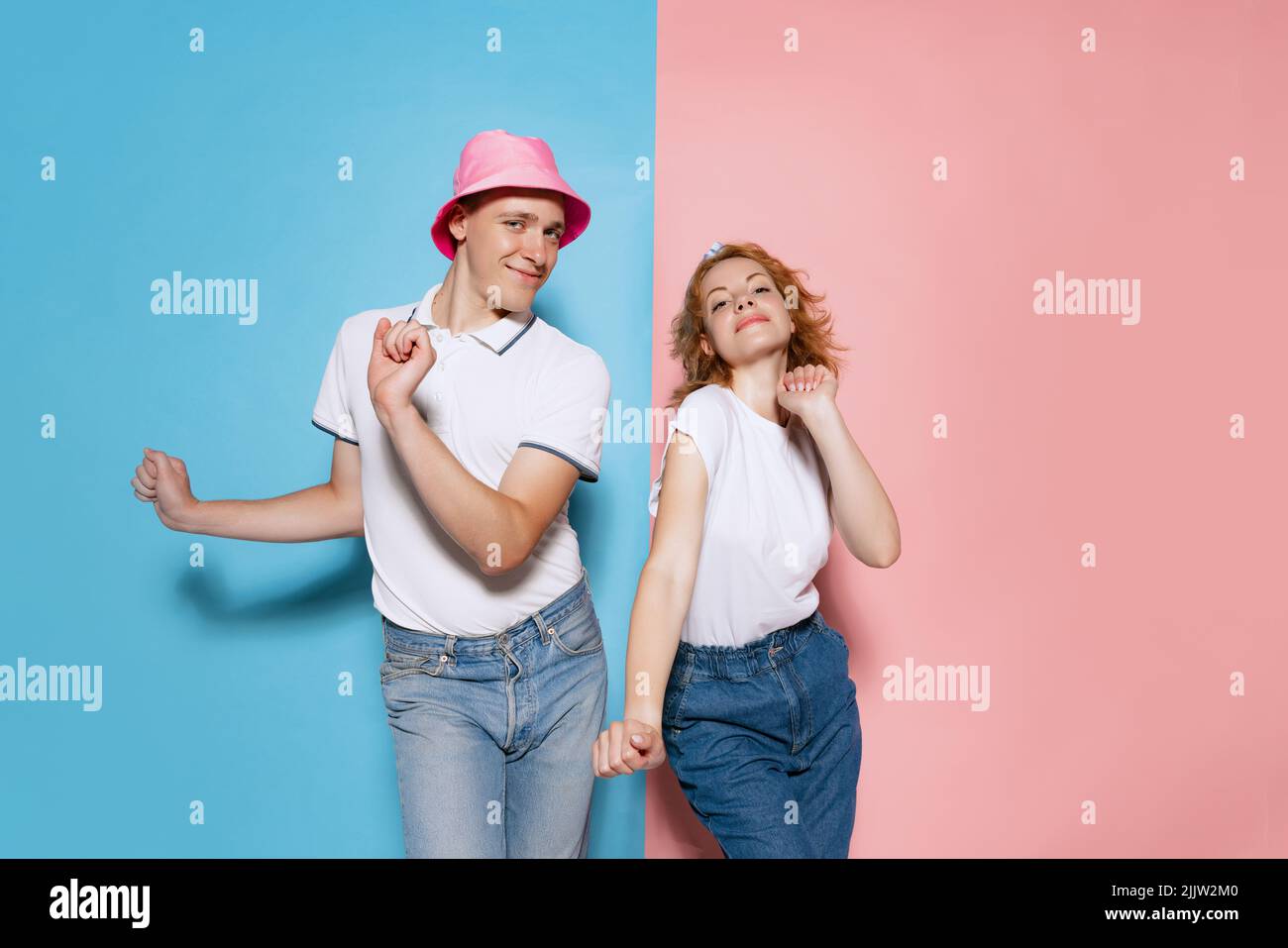 Portrait of young cute couple, cheerfully dancing, posing isolated over ...