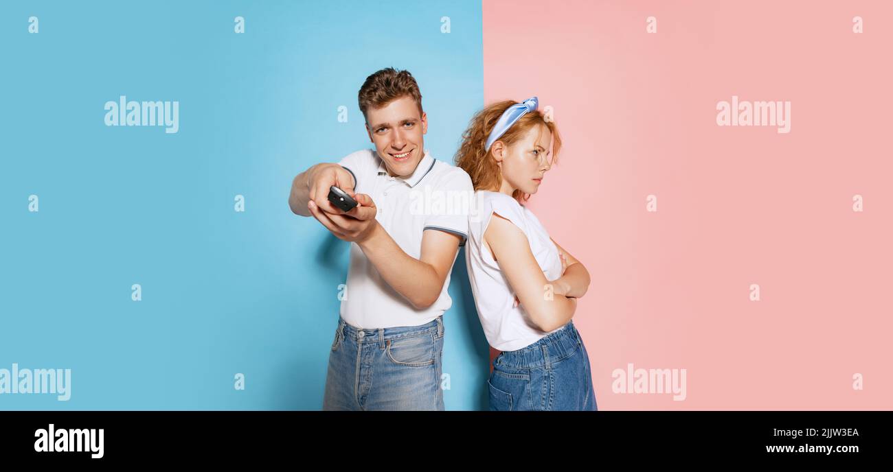 Portrait of young couple isolated over pink blue studio background. Man ...