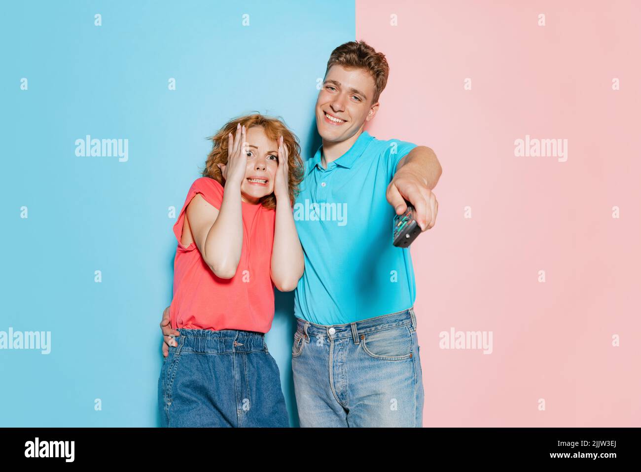 Portrait of young couple with terrified expression, watching horror ...