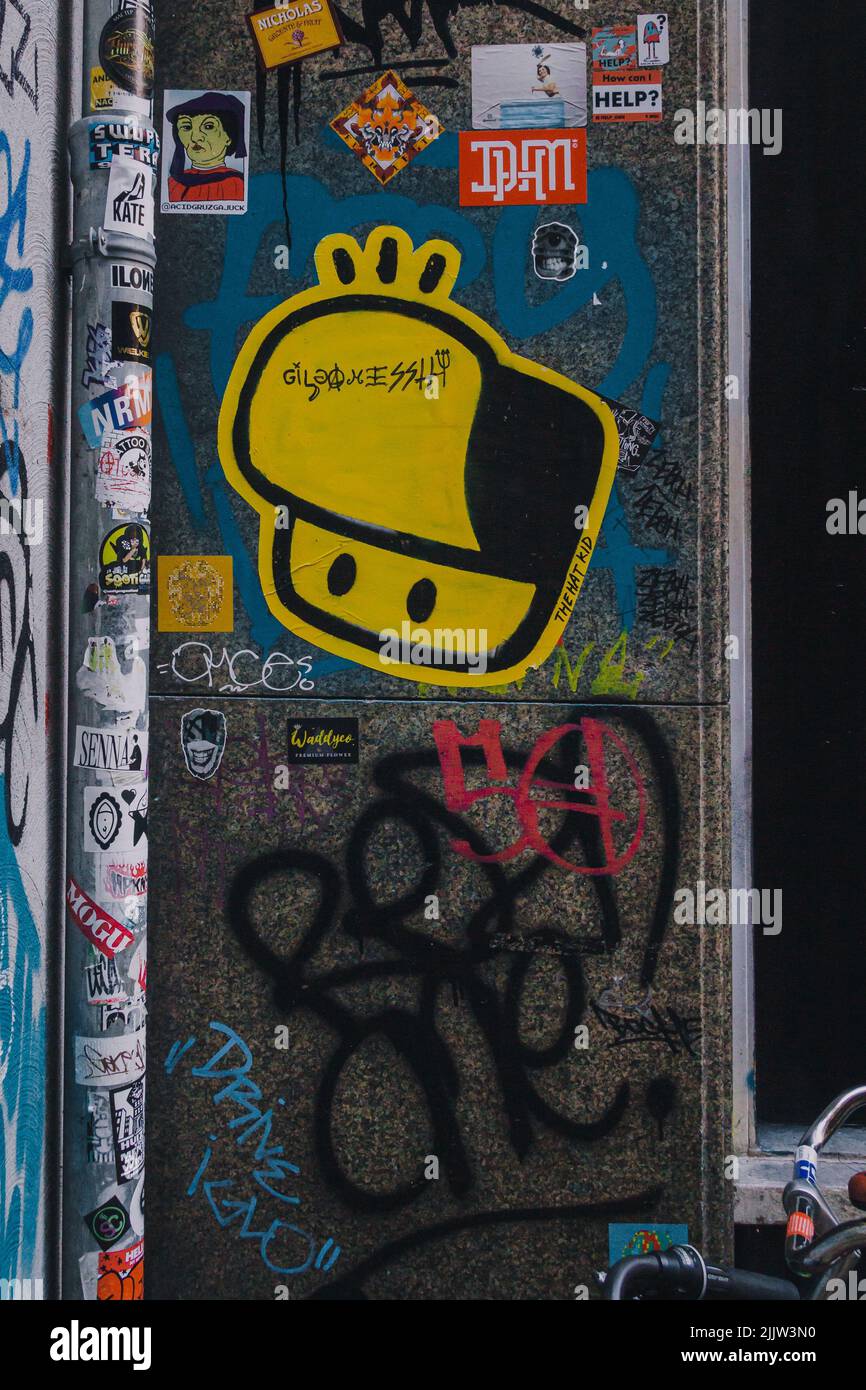 A vertical shot of a colorful street graffiti on a background of a wall ...