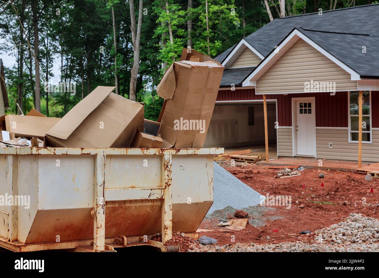 Industrial dumpster filled rubbish removal container on house under ...