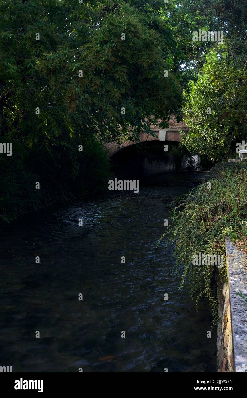 Stream of water in the shade with a brick bridge Stock Photo - Alamy