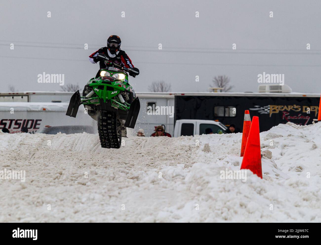 Snowmobiler competing in extreme sports. Snowmobile jumps above the ...