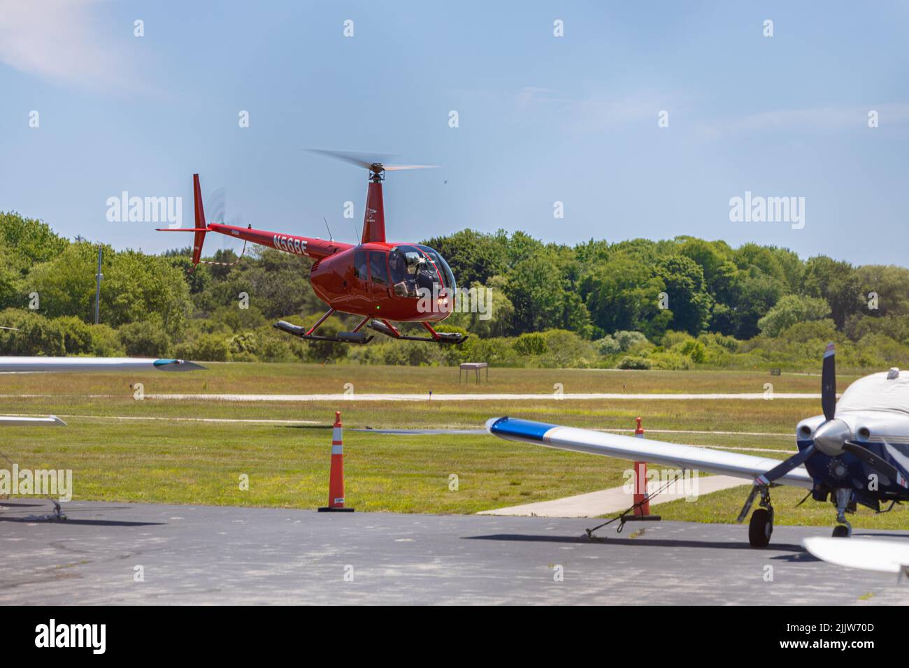 A red helicopter taking off at an airport on a sunny morning Stock ...
