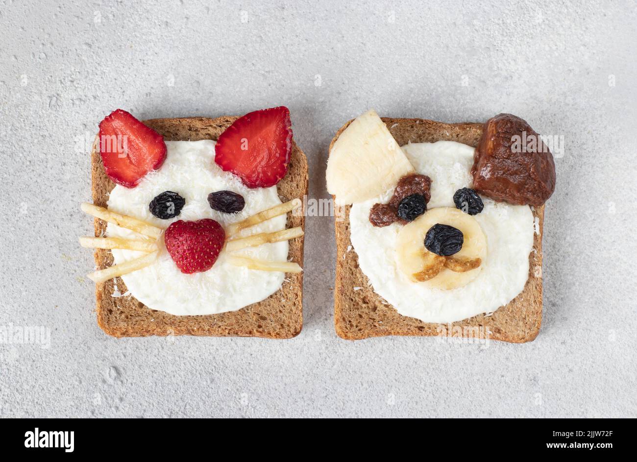 Two sweet toasts for kids in shape of cat and dog with strawberries ...