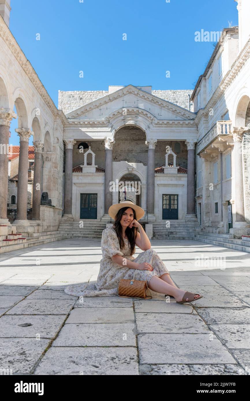 A beautiful Caucasian woman sitting on the floor at the peristyle of ...