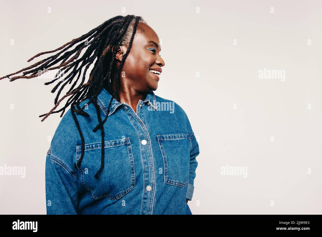 Dreadlocks fun. Excited mature woman smiling and whipping her ...