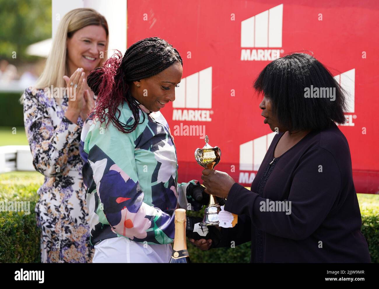 Jockey Ashleigh Wicheard receives the trophy after riding Dark Shot to ...