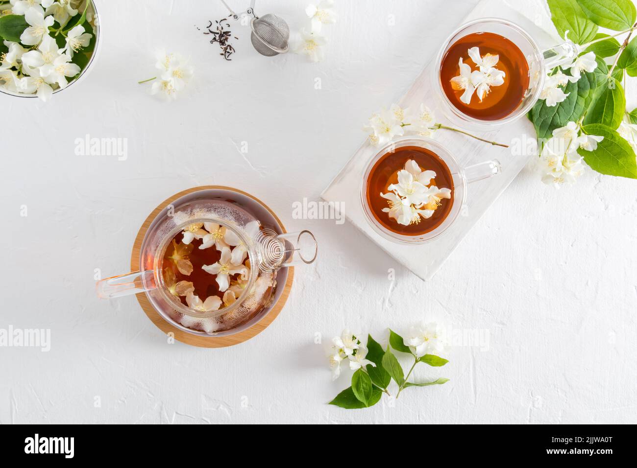 top view of a white textured background with a teapot and two glass ...