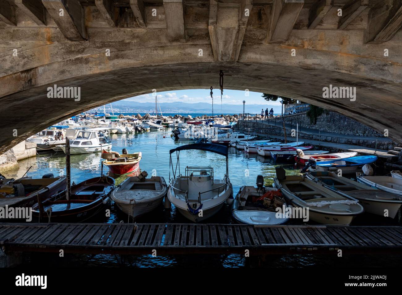 Dreamy harbor view with small boats under a bridge Stock Photo - Alamy