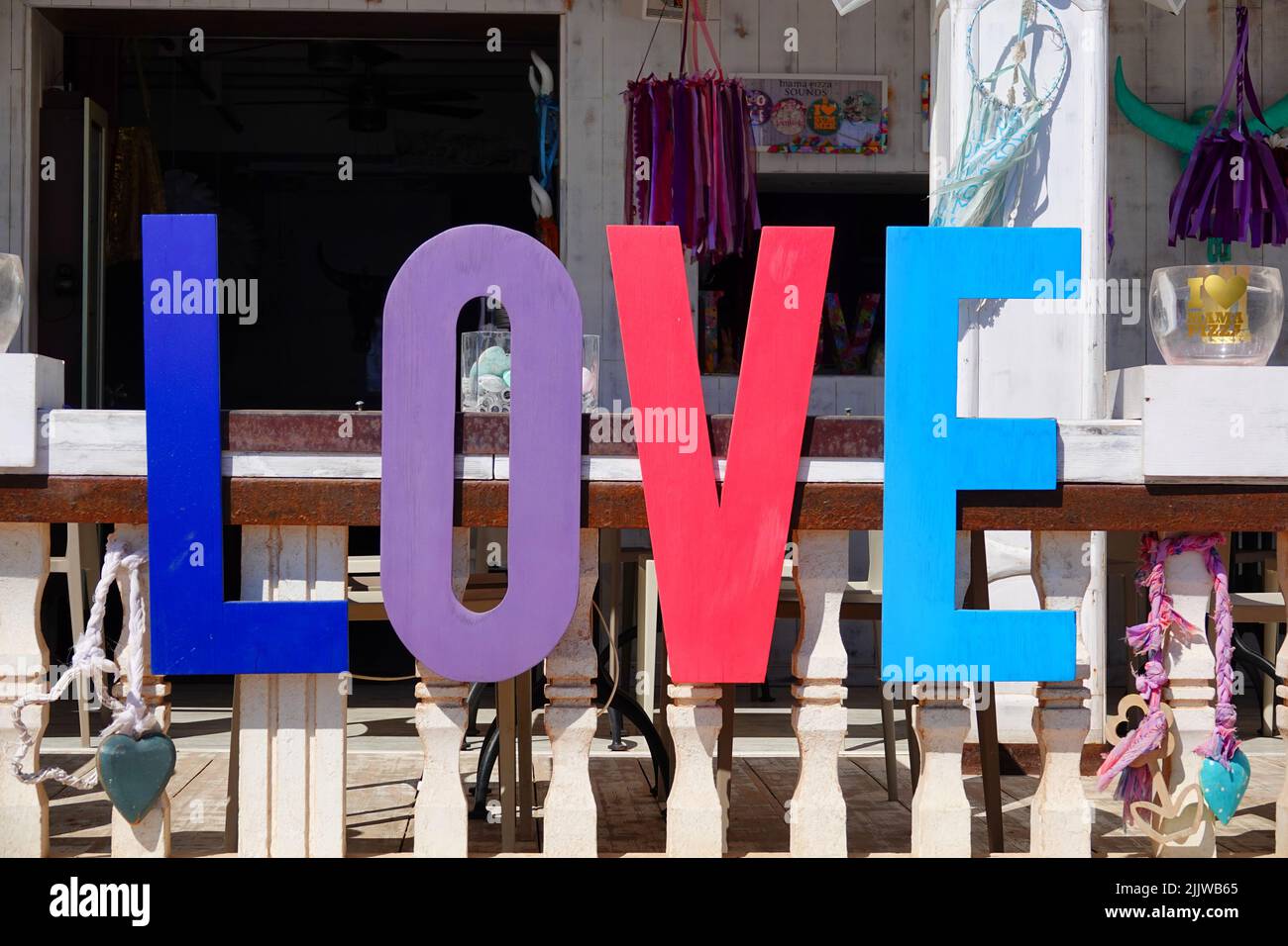 Picture shows a olourful, wooden lettering LOVE on the veranda of a ...