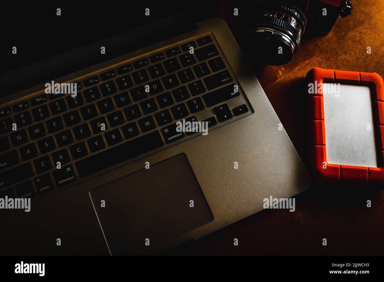 A top view of a laptop, external hard drive and a professional camera ...