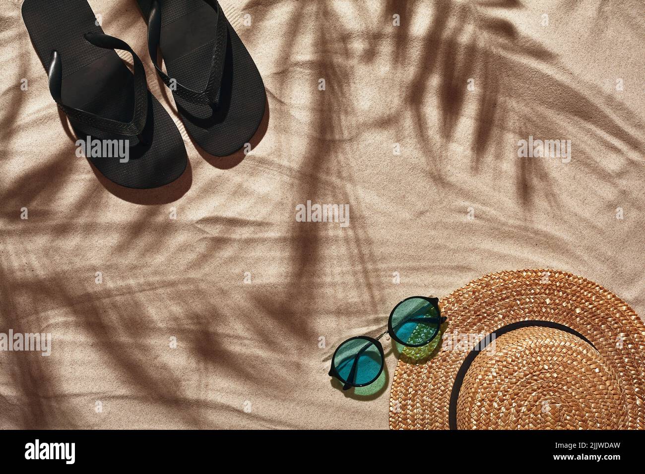 Traveler vacation accessories are laid out on a white beach sand. Flat ...