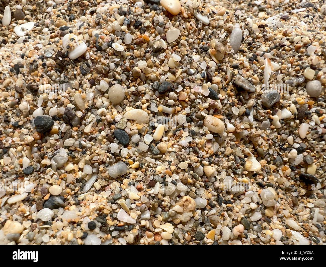 Sandy background with small stones on the beach Stock Photo - Alamy