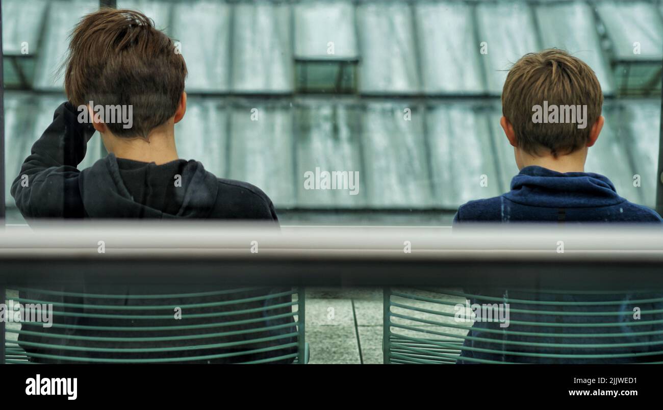 A back view of two young boys sitting on a bench Stock Photo - Alamy