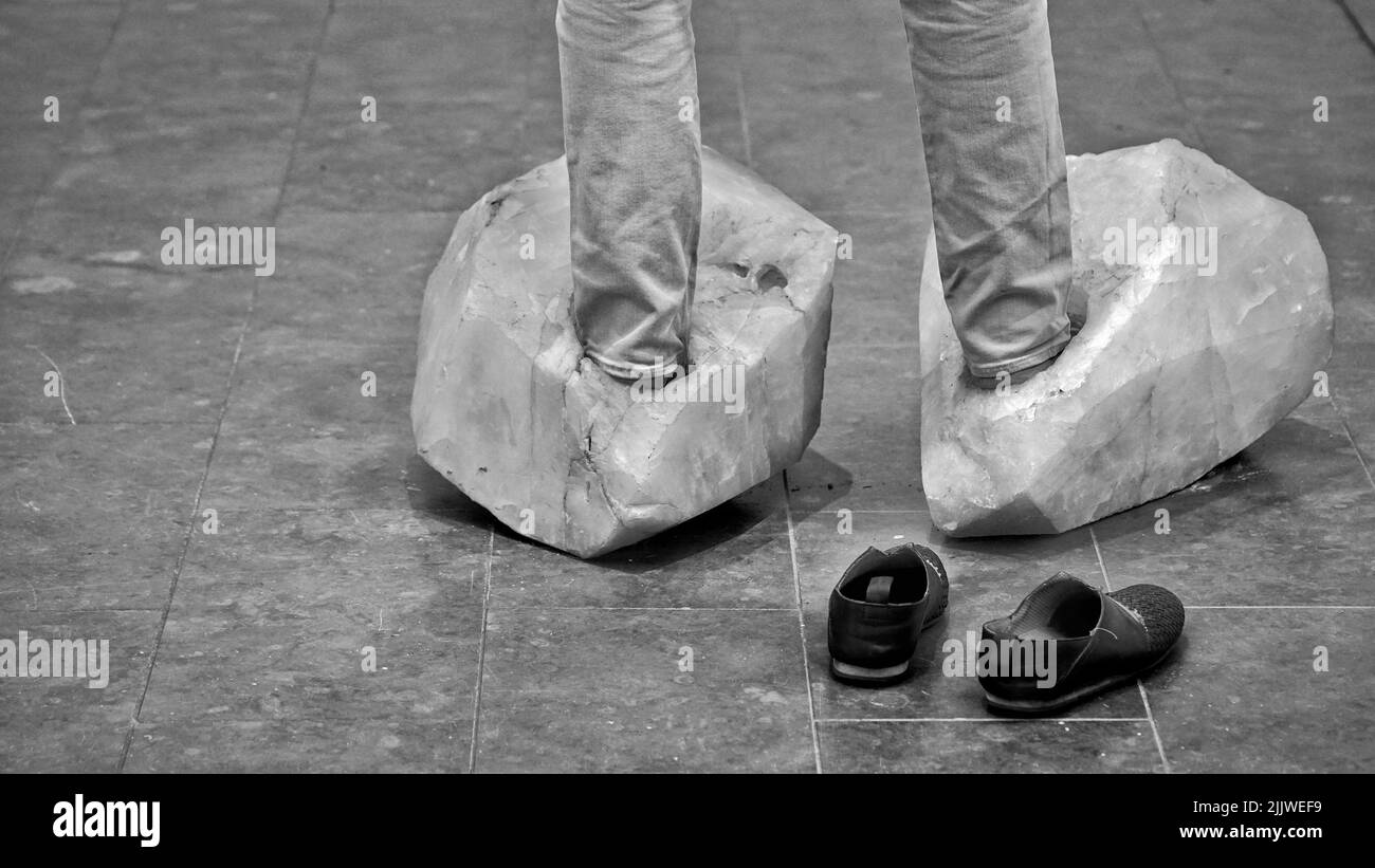 A grayscale shot of male feet in marble stones Stock Photo - Alamy