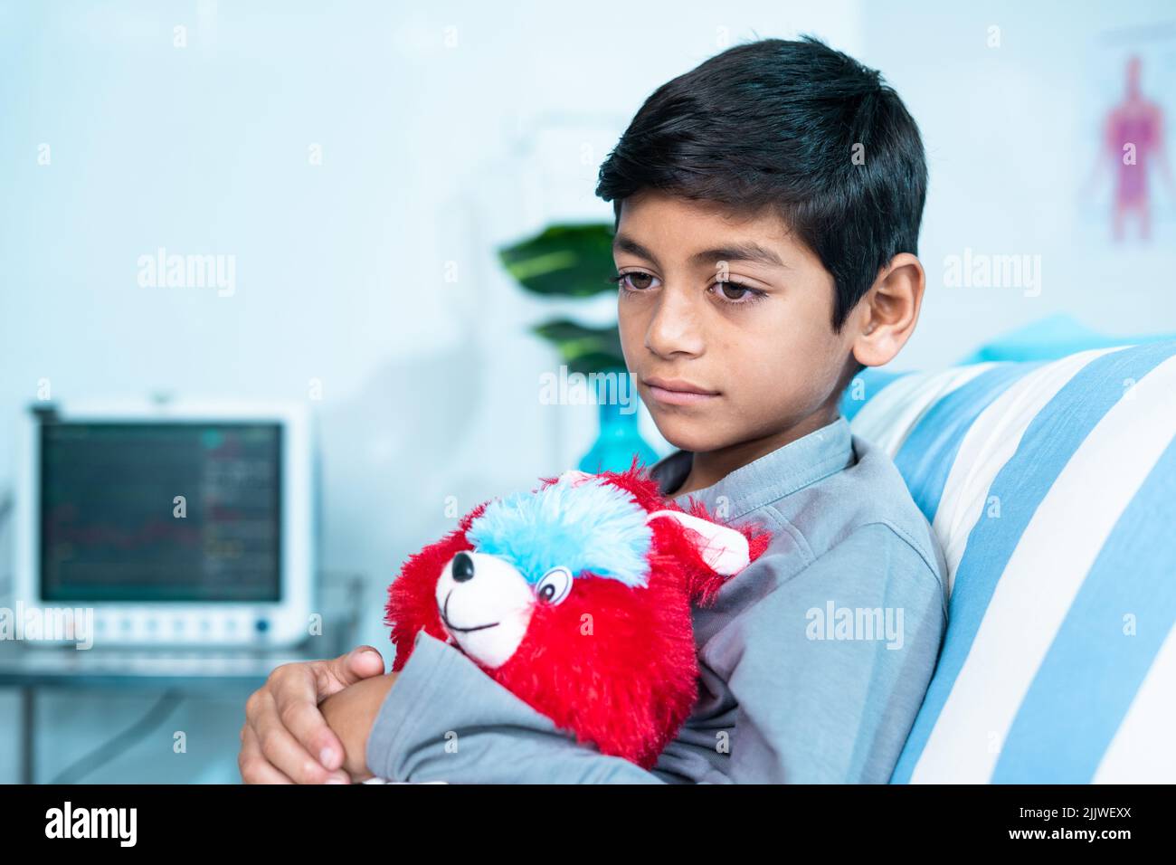 Sick sad thoughtful child with teddy bear sitting on admitted hospital ...
