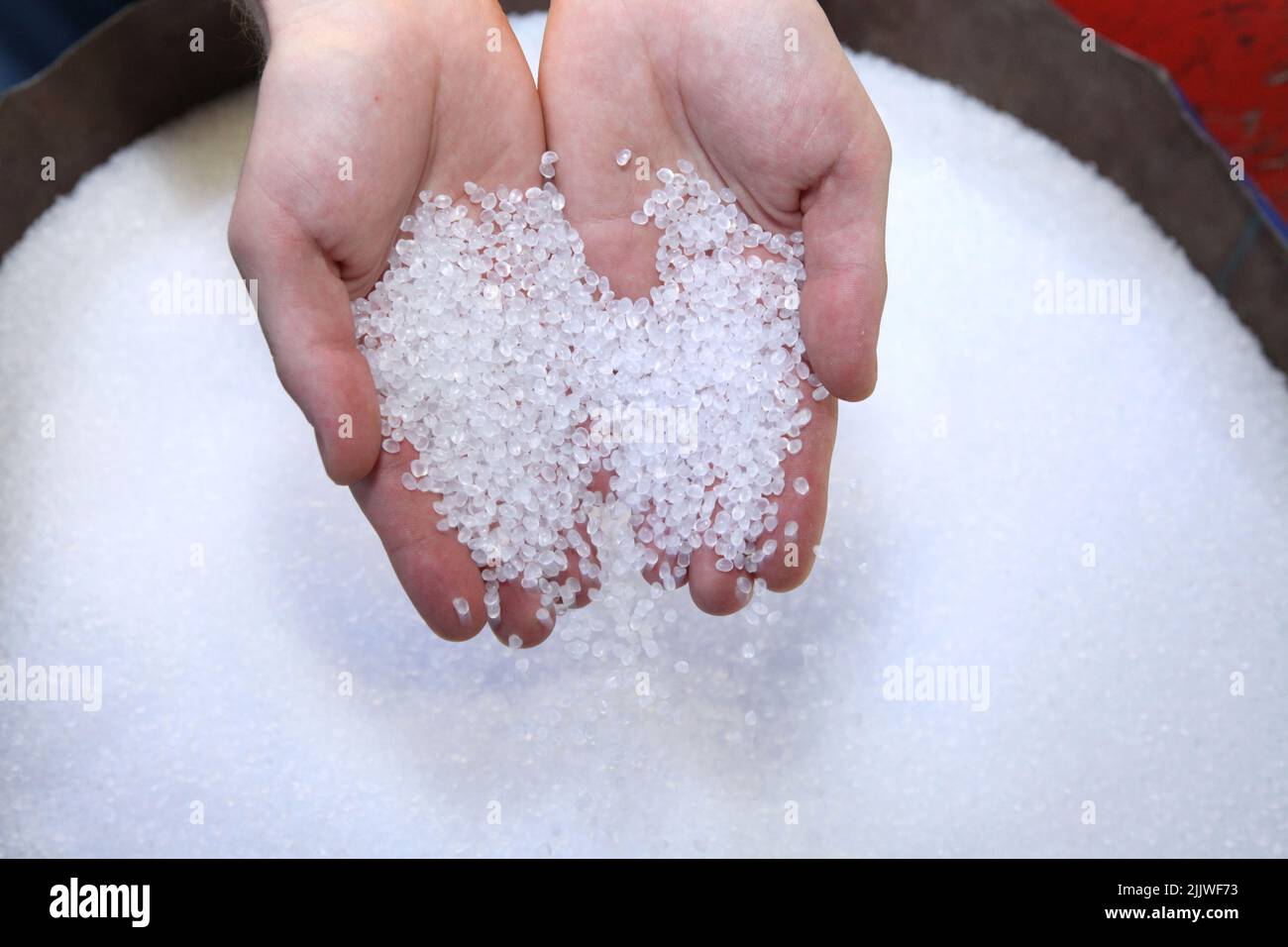 Plastic granules in human hands. Quality checking Stock Photo - Alamy