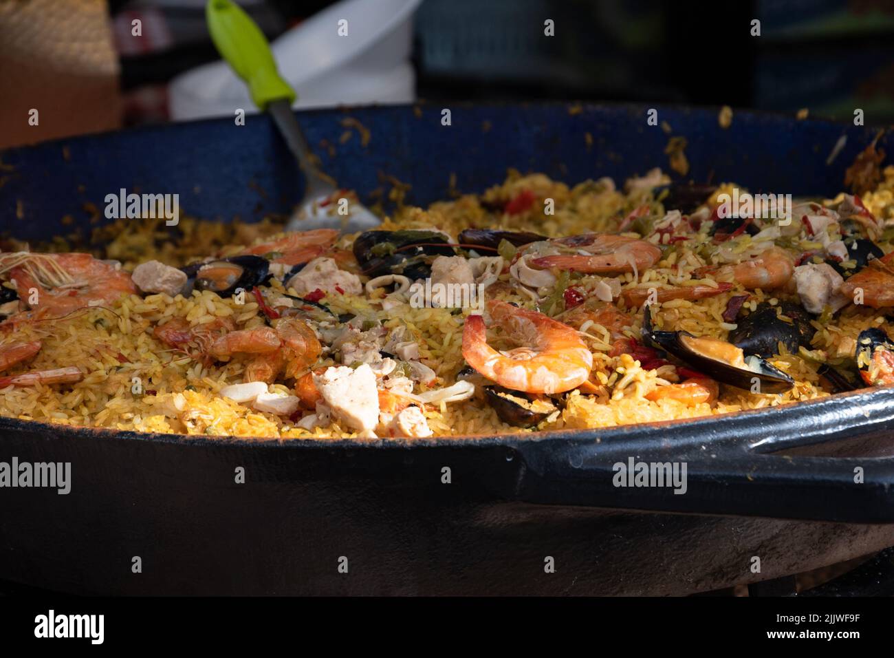 Traditional paella with seafood and chicken at food market in Paris ...