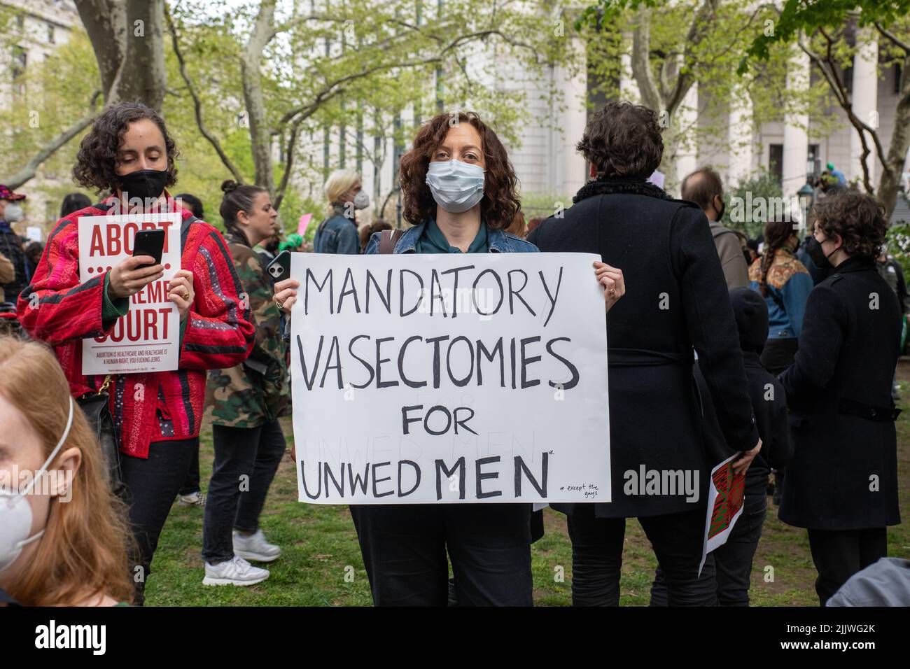 A young Female holding a cardboard sign at Foley Square, New York, NY ...