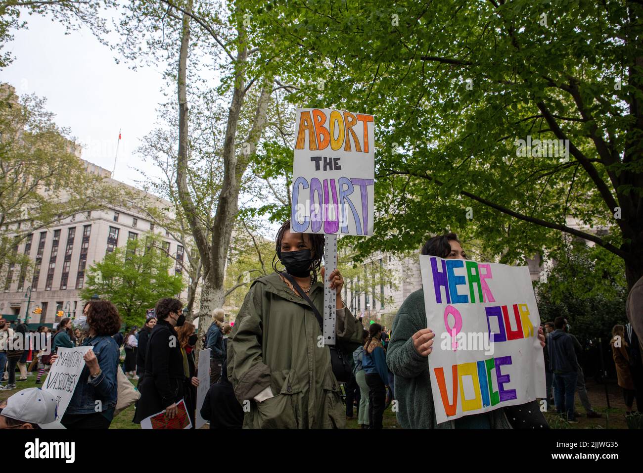 A young female holding a cardboard sign at Foley Square, New York, NY ...