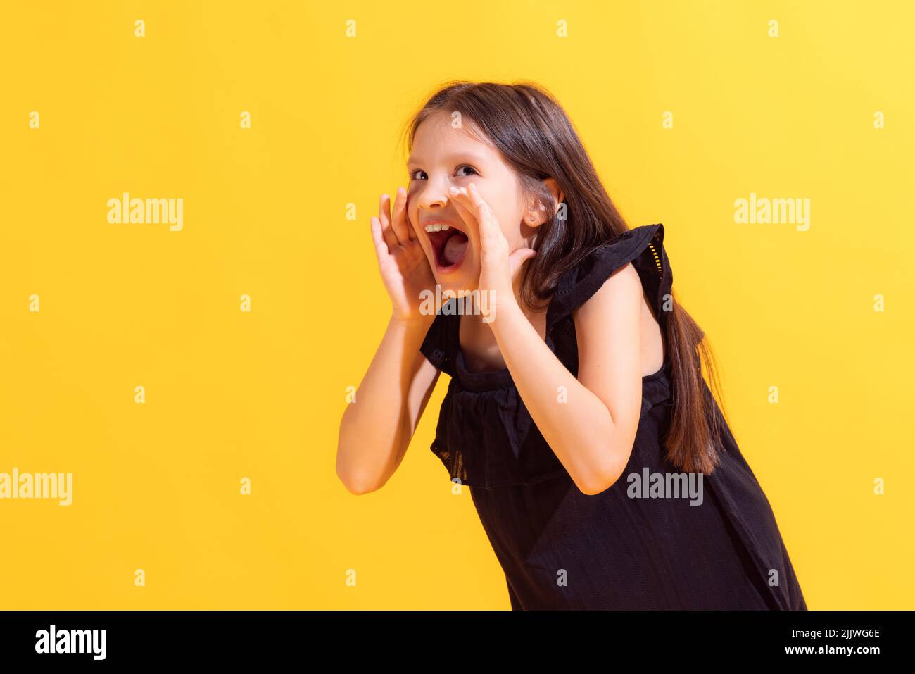 Shouting little girl, kid wearing black dress shouting isolated on ...
