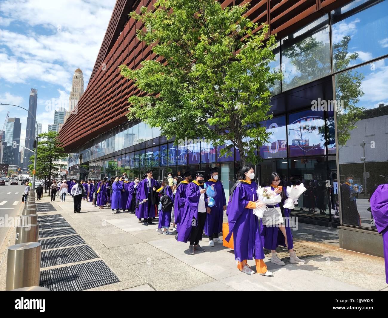 A crowd of graduating students in caps and gowns waiting to get into ...