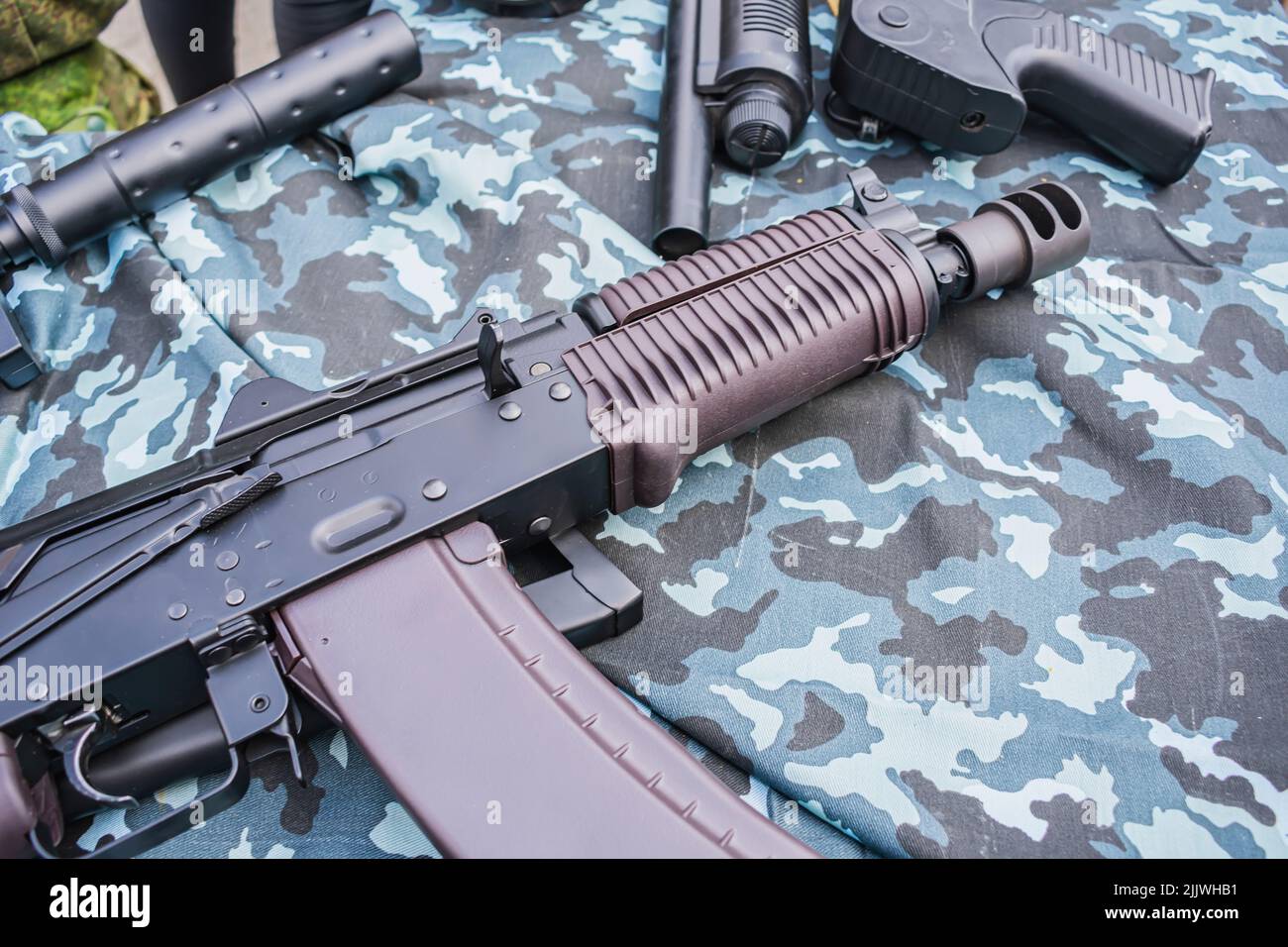 A machine gun with a clip is laid out on the table among various ...