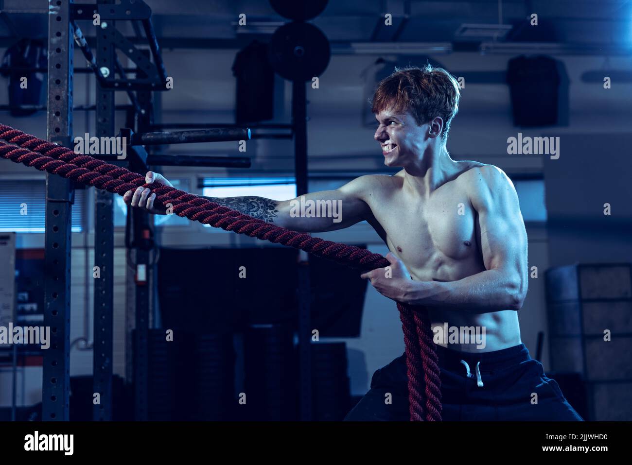 Portrait of muscular red-haired man training, doing exercises with ...