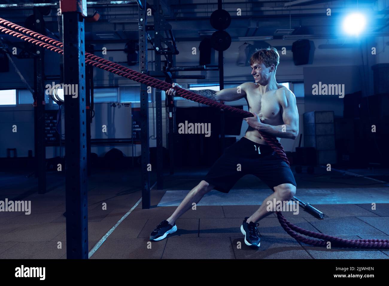 Portrait of muscular red-haired man training, doing full body exercises ...