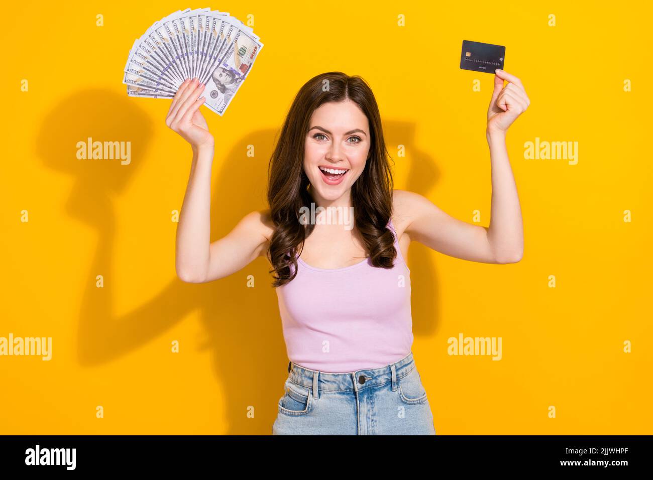 Photo of excited positive lady hold debit card dollar banknotes ...