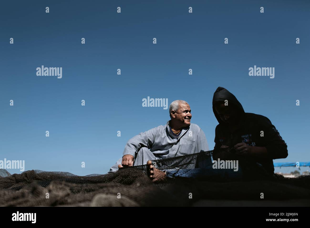Two net makers sitting outside and practicing their craft in Rashid ...