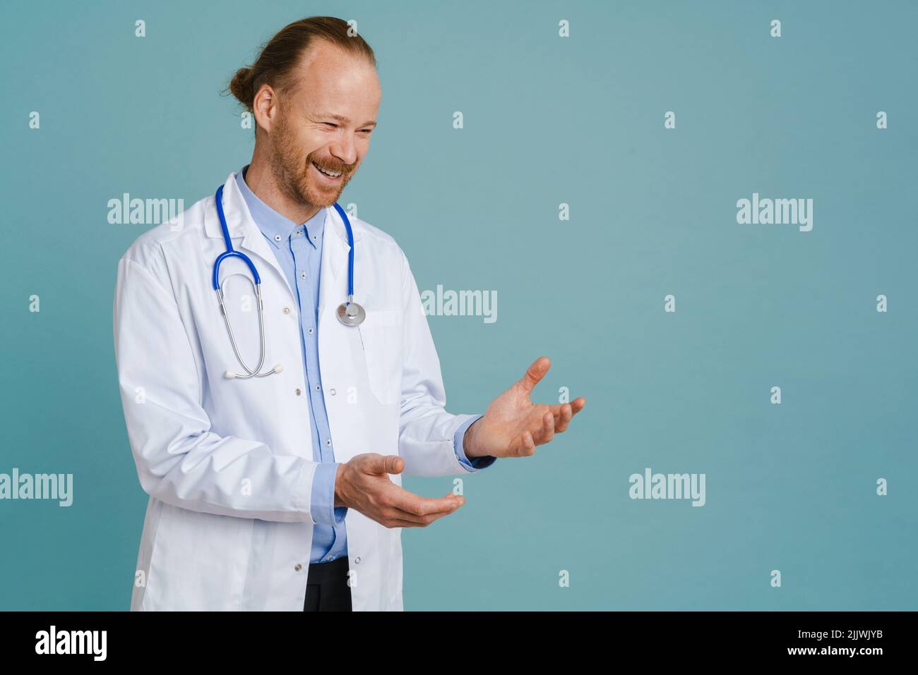 White male doctor wearing lab coat smiling and holding copyspace ...