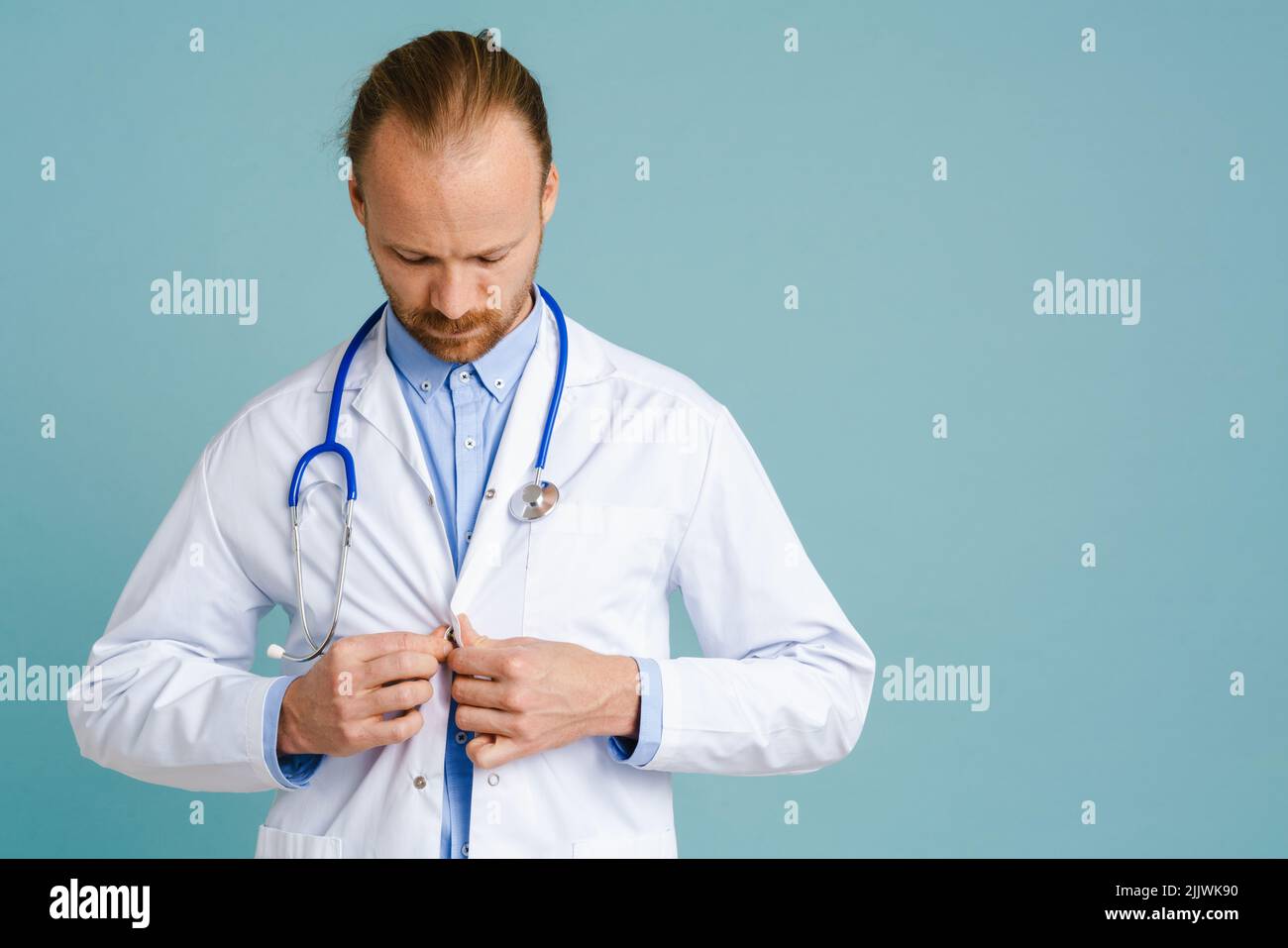 White male doctor wearing lab coat posing with stethoscope isolated ...