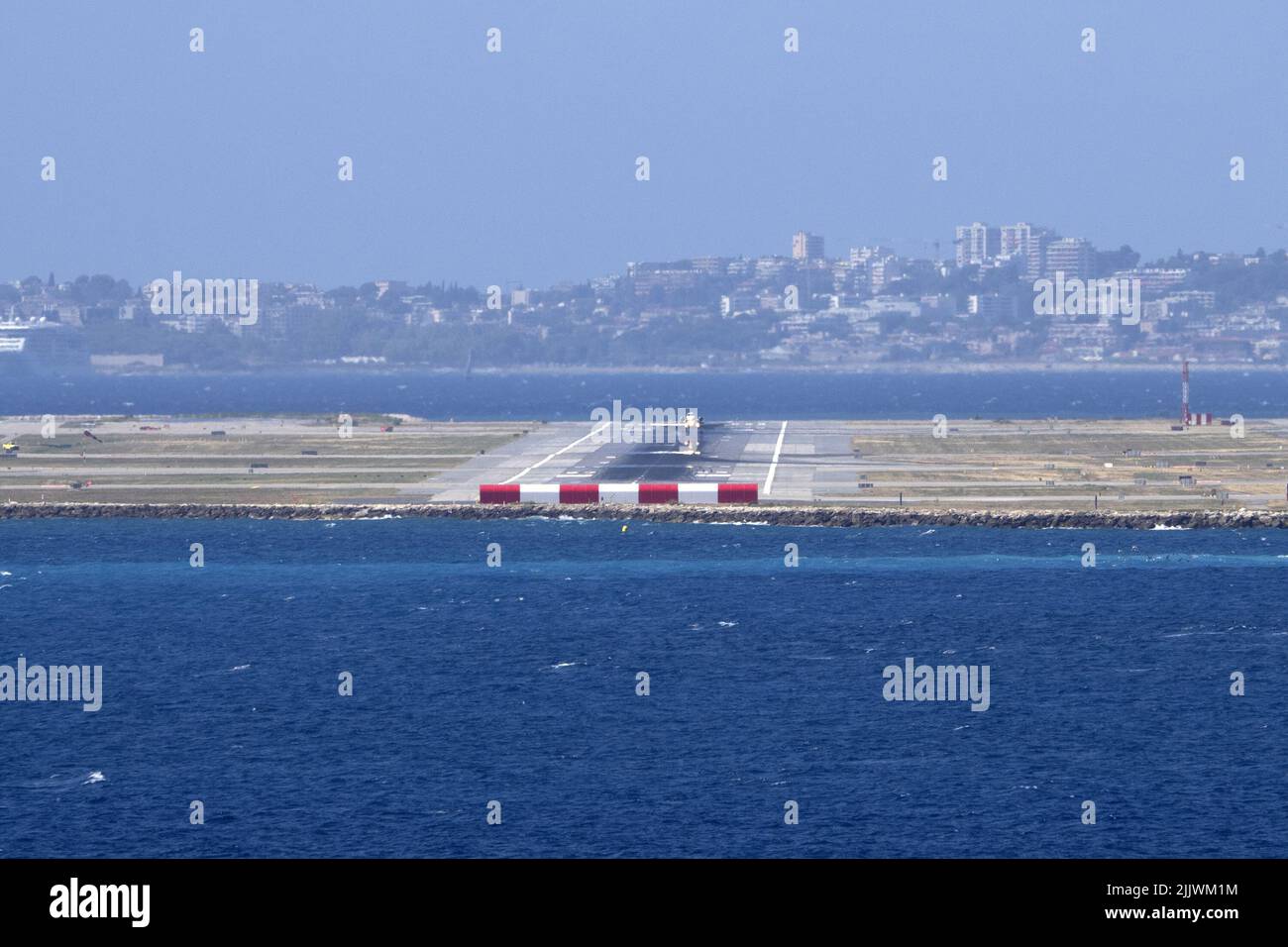 plane landing in by the sea nice airport france Stock Photo - Alamy