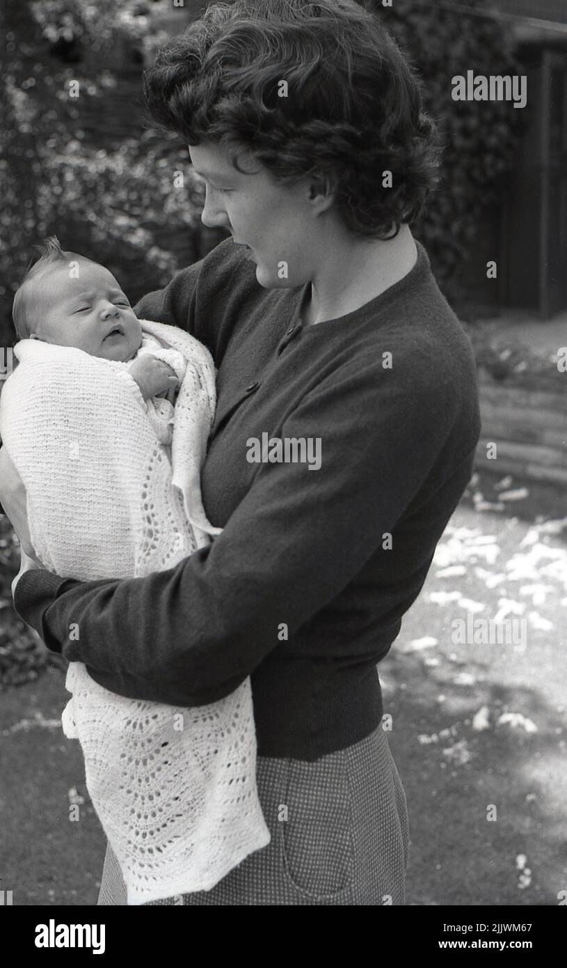 1960s, historical, outside, a mother holding closely her newly born ...