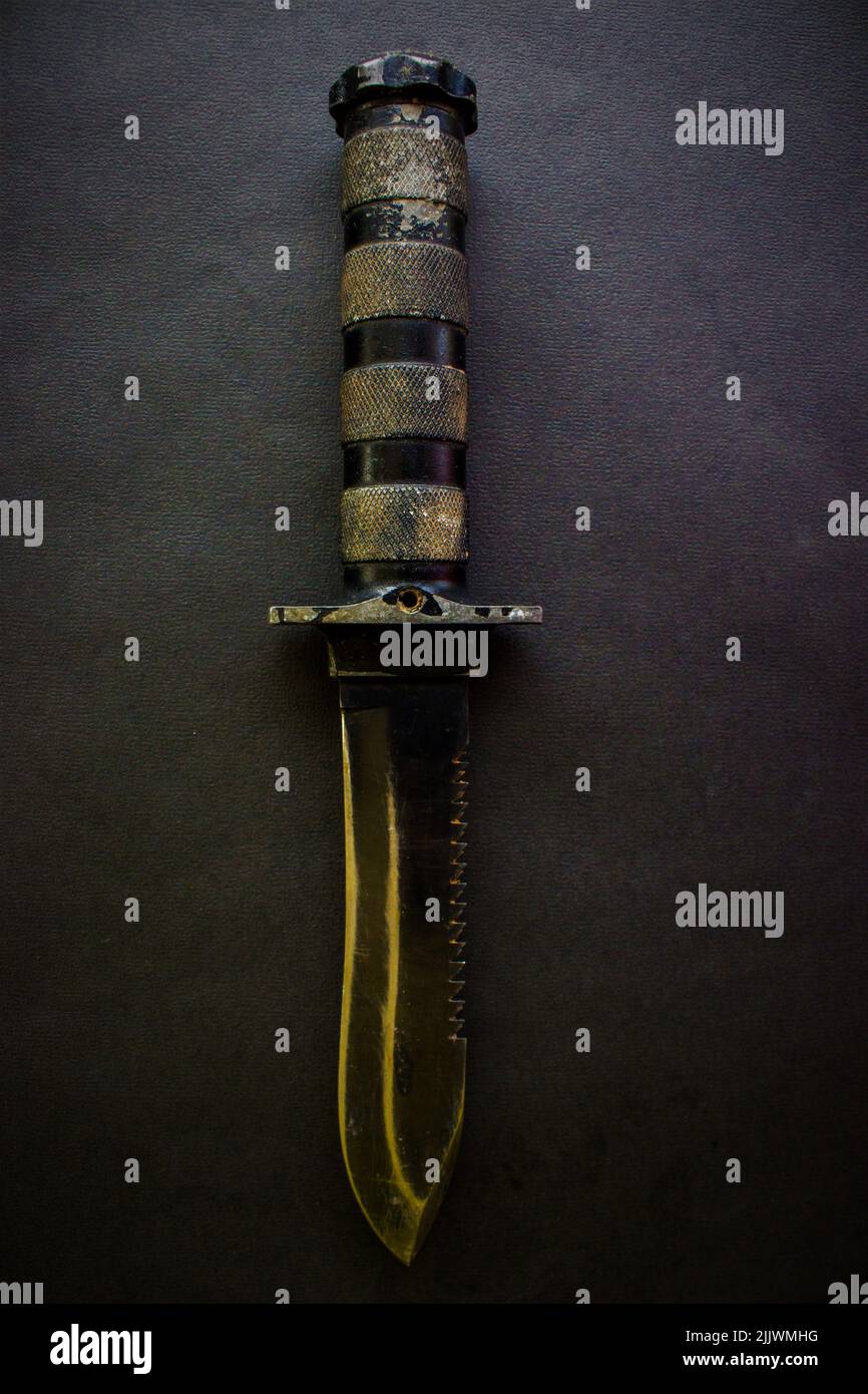 dark black military knife on black background Stock Photo - Alamy
