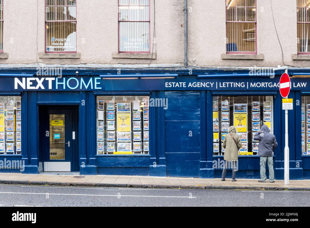 People looking in the window of Next Home estate agency in Perth ...