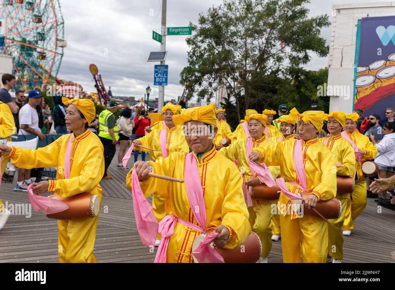 A group of women in traditional yellow costumes with drums at the 40th ...