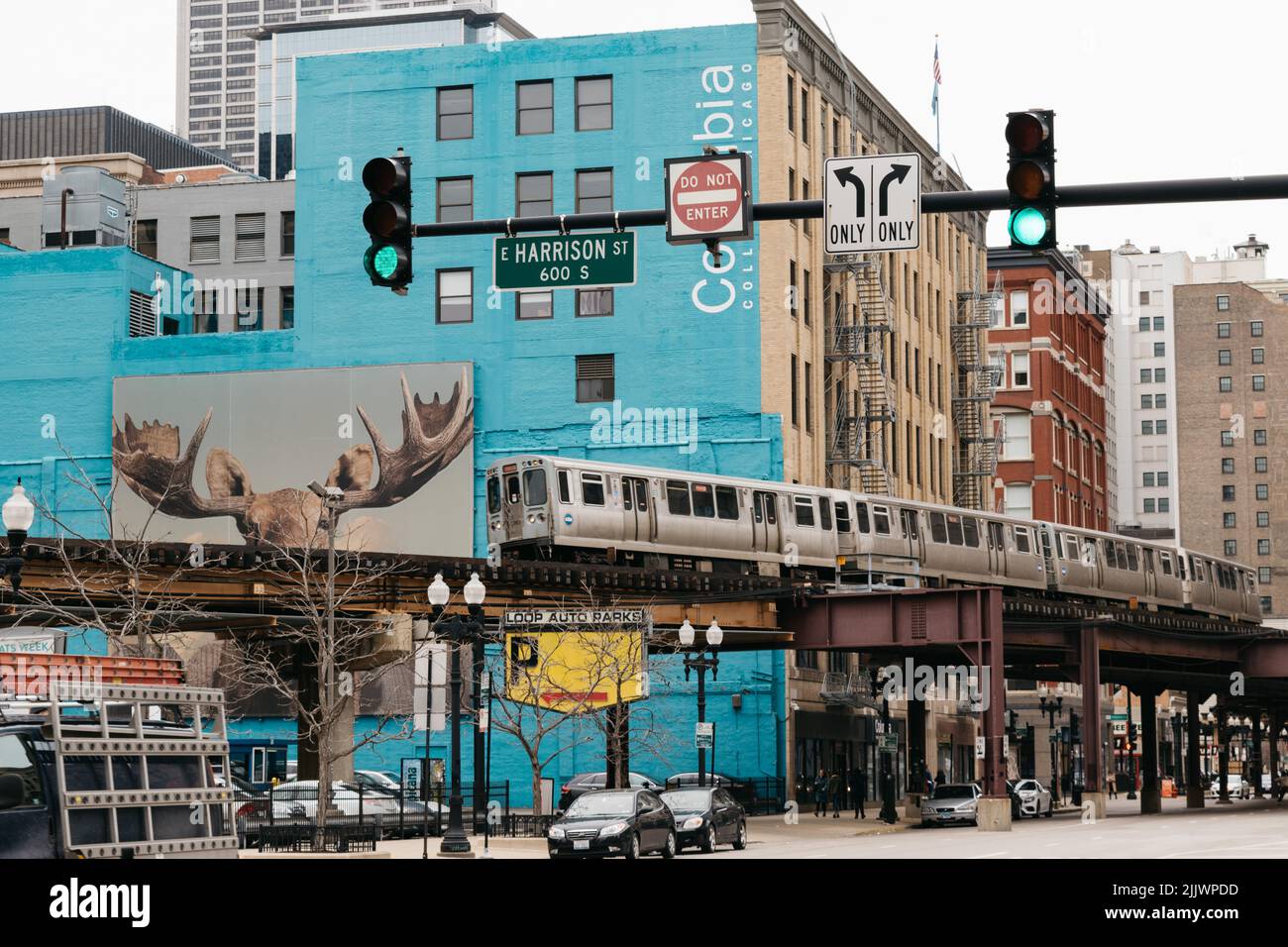 A street view in Chicago city, train over bridge and cars in the street ...