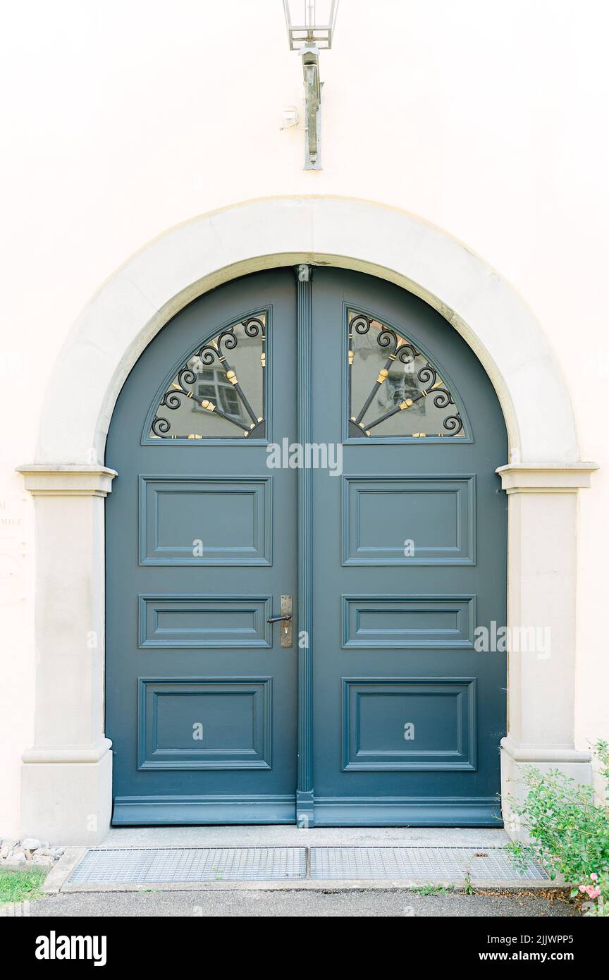 A vertical shot of a blue arched ornate double door Stock Photo - Alamy