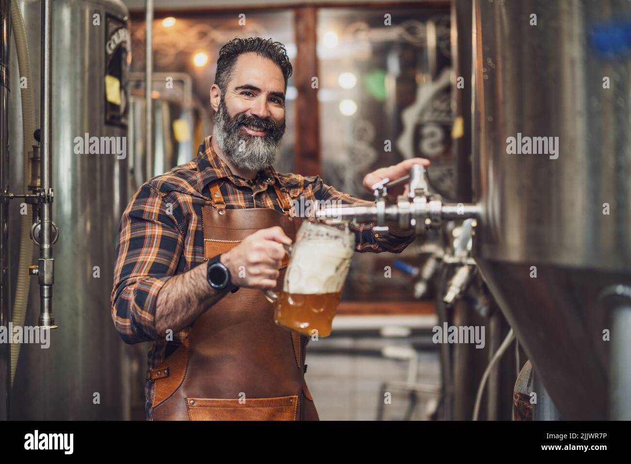 Brewery master tasting beer in production facility. Small family ...