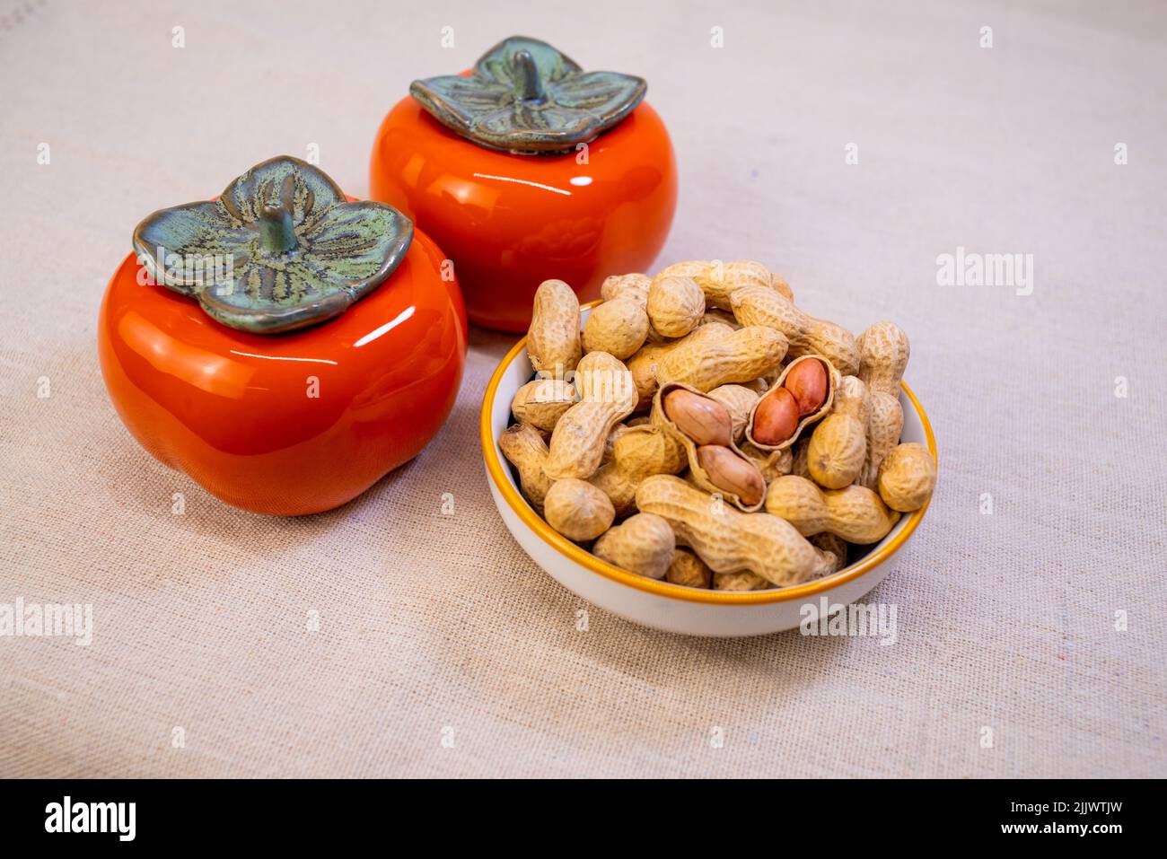 A Persimmon-shaped decorations and peanuts are placed on the background ...
