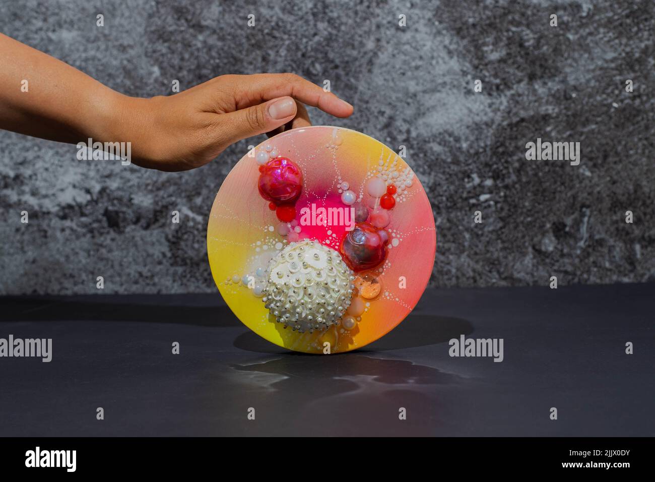 A pink and yellow round circle glitter blob art work of microcosmos ...