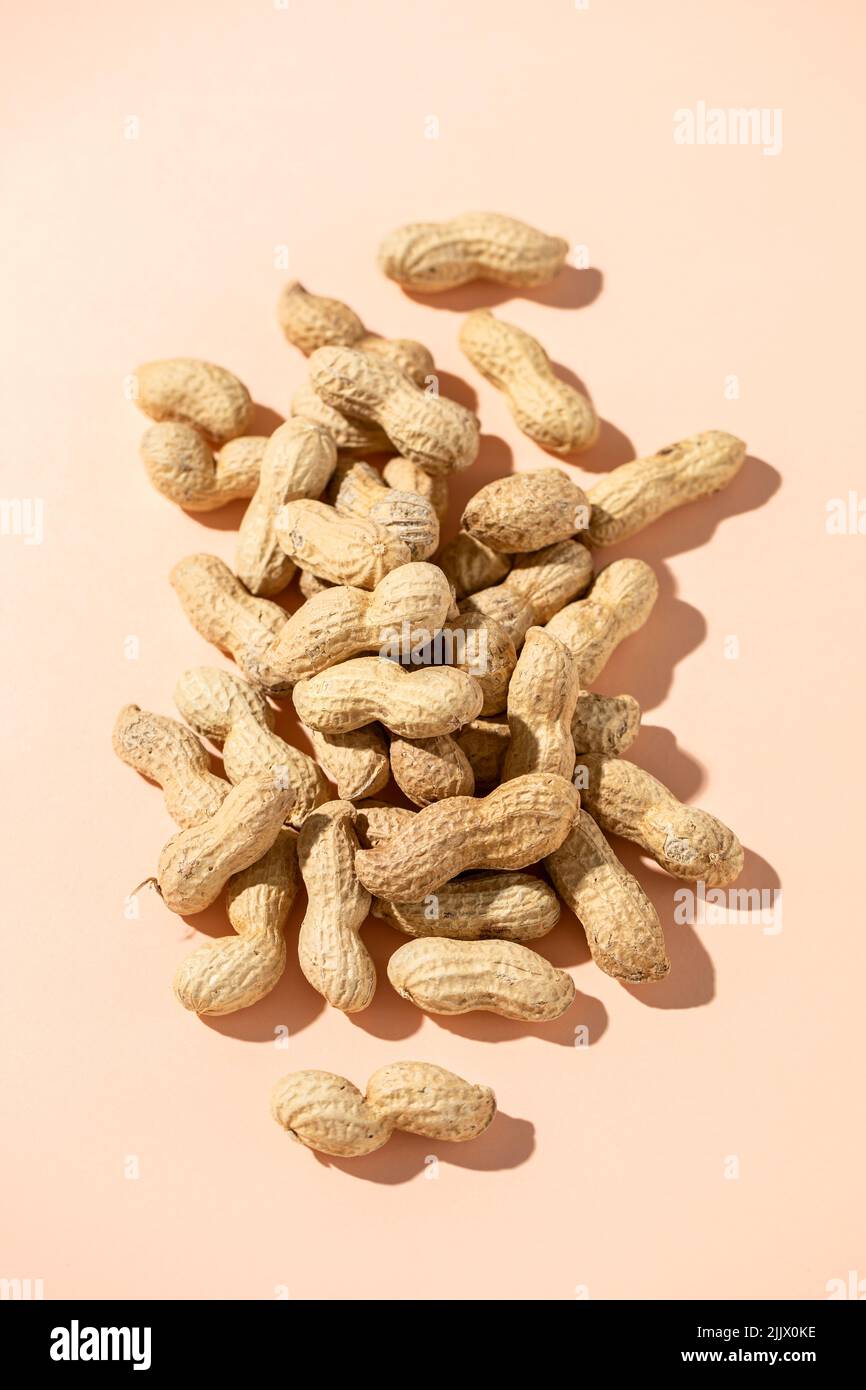 Top view pile of fresh peanuts in shells on peach background Stock ...